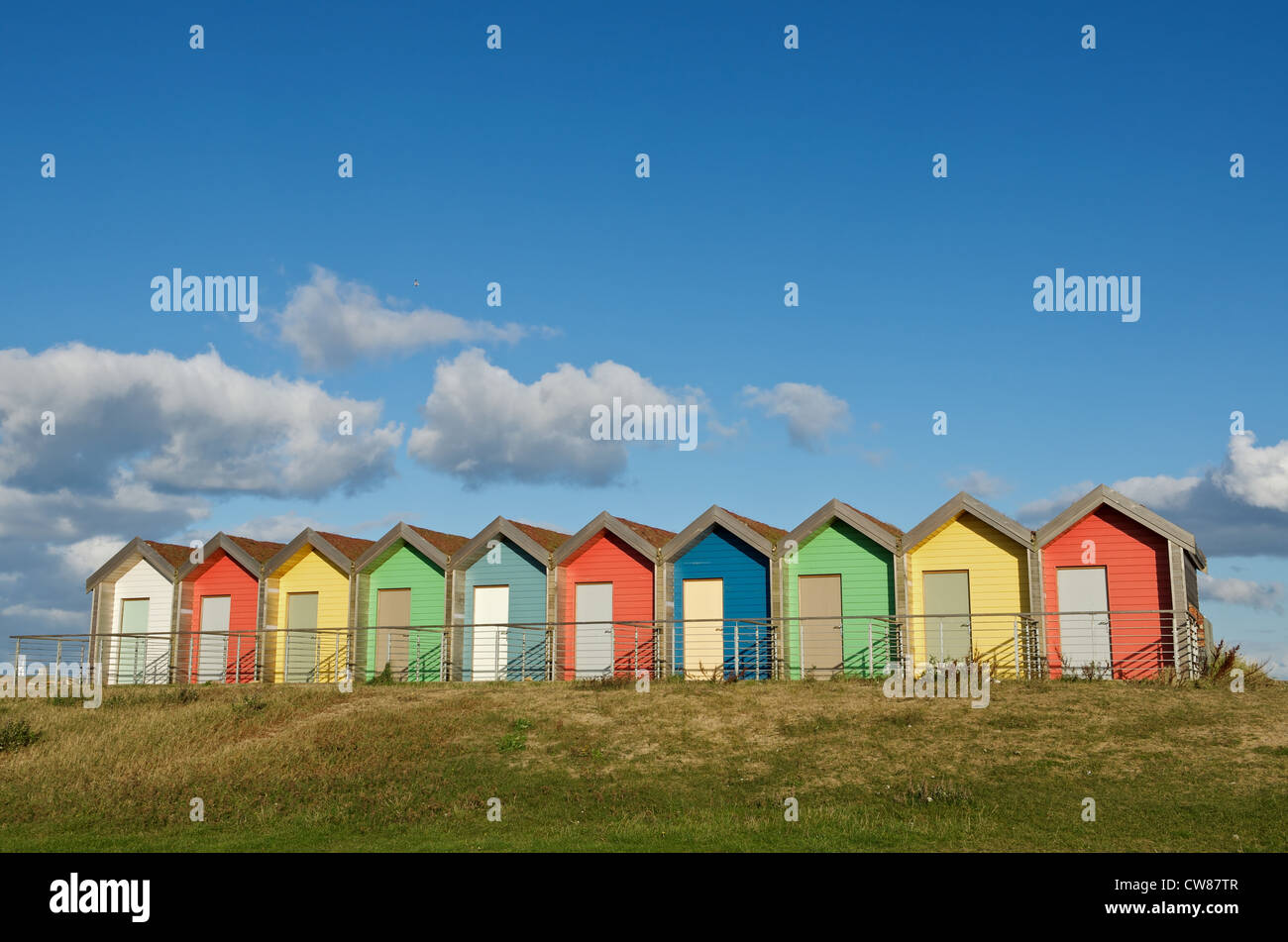 A row of multi colored beach huts beside the sea at Blyth ...