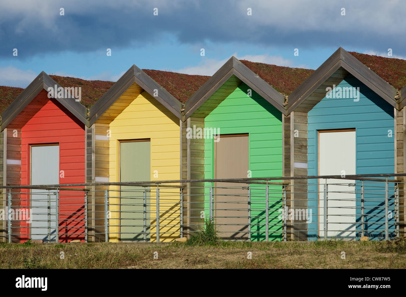 A row of brightly colored beach huts on the North Sea coast in Blyth ...