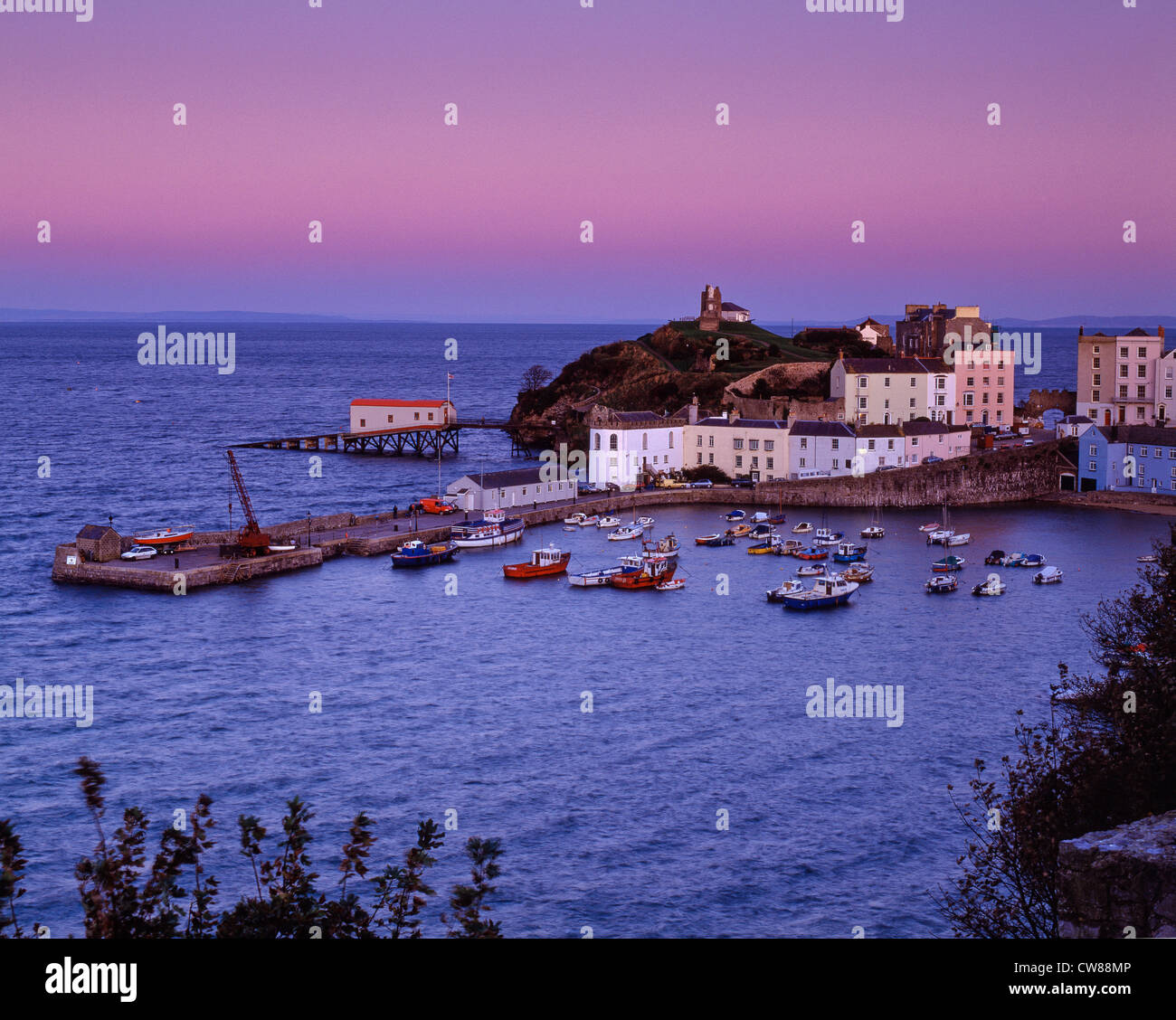 Tenby Harbour and old lifeboat station with boats in harbour at sunset ...