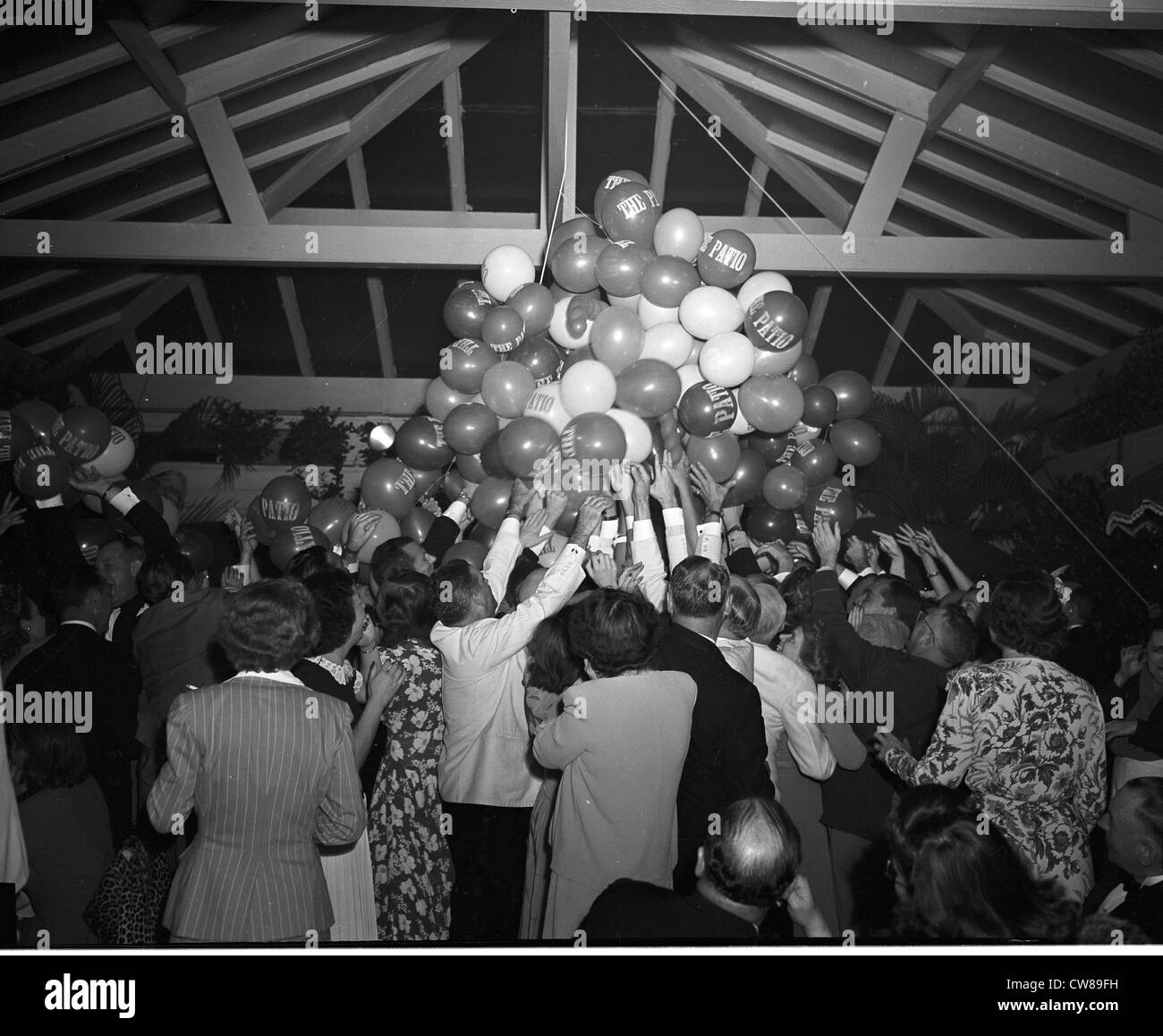 A crowd reaches for balloons suspended from rafters during Gala Night ...