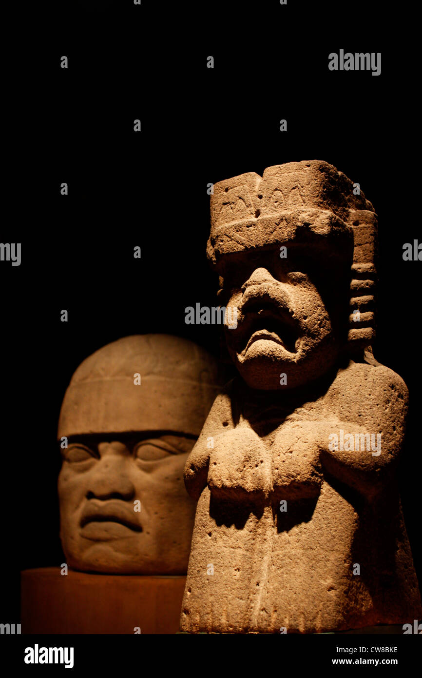A sculpture is displayed in front of the Olmec giant head in the ...