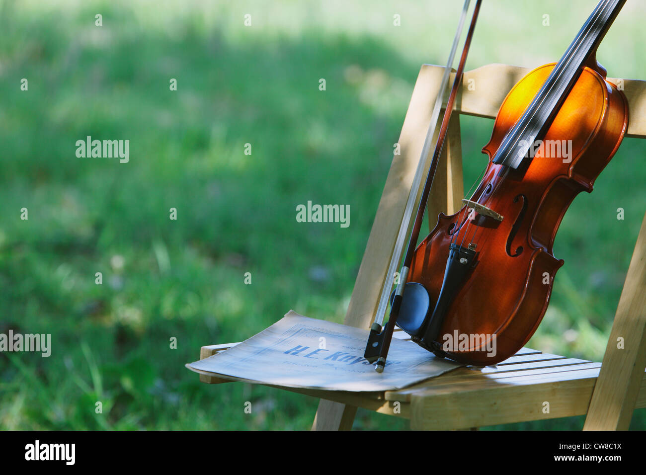 Violin At Wooden Chair Stock Photo - Alamy