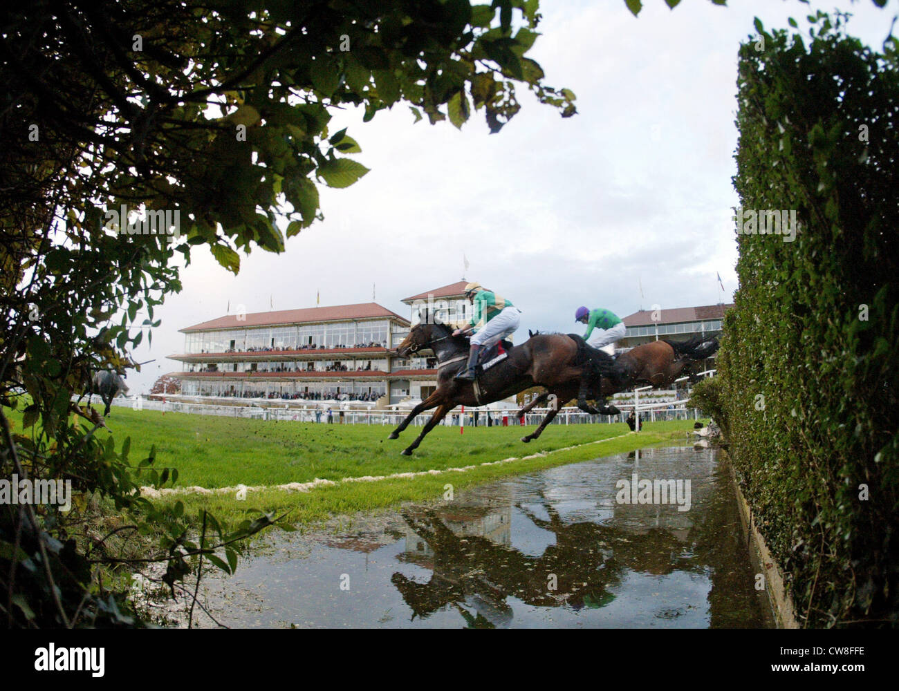 Iffezheim, race horses and their jockeys jump over a ditch Stock Photo ...