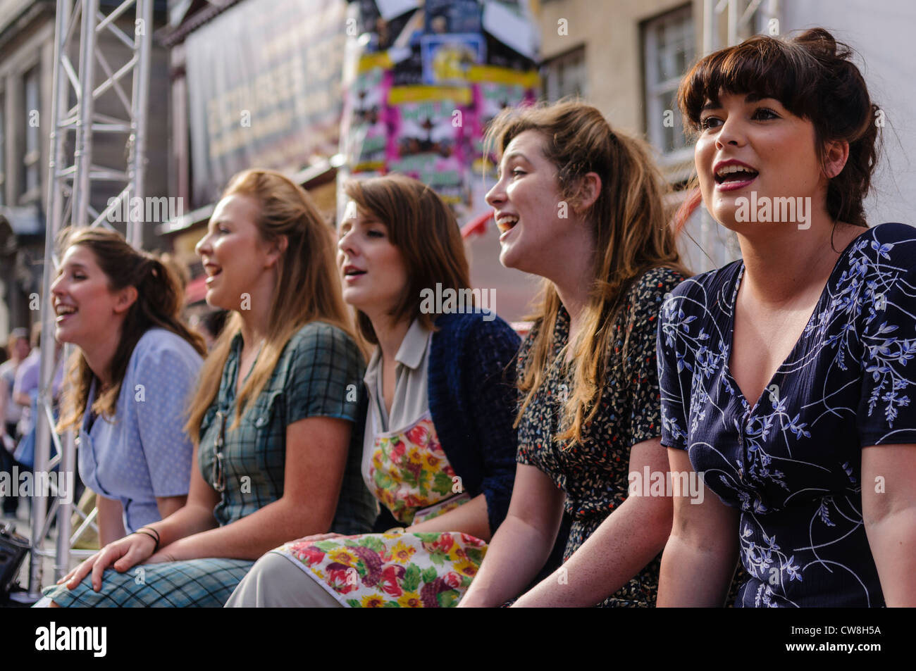 Five ladies singing 1940s style and wearing dresses from the era ...