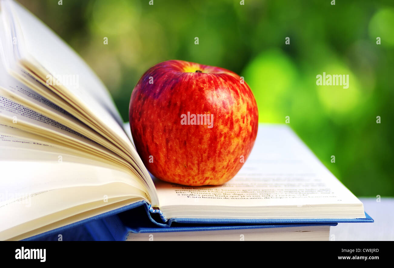 Apple on open book Stock Photo - Alamy