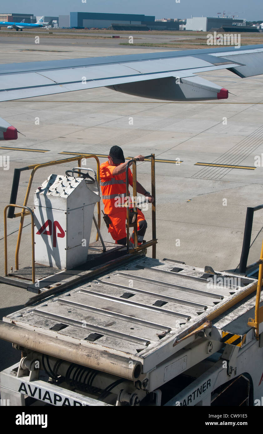 Airport worker & cargo loading belt on the apron at Toulouse Airport ...