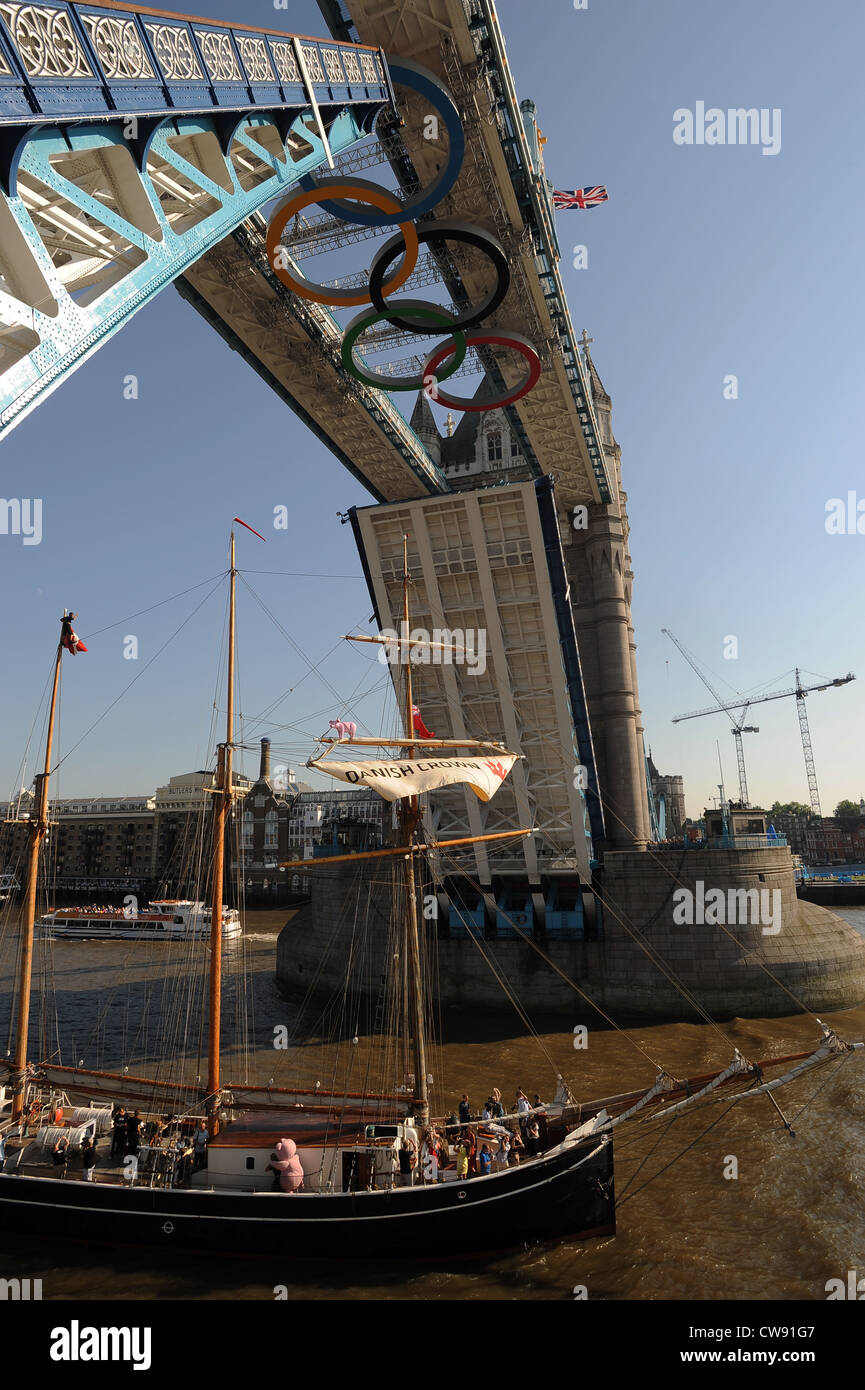 Boats sailing under Tower Bridge with Olympic rings raised Stock Photo ...