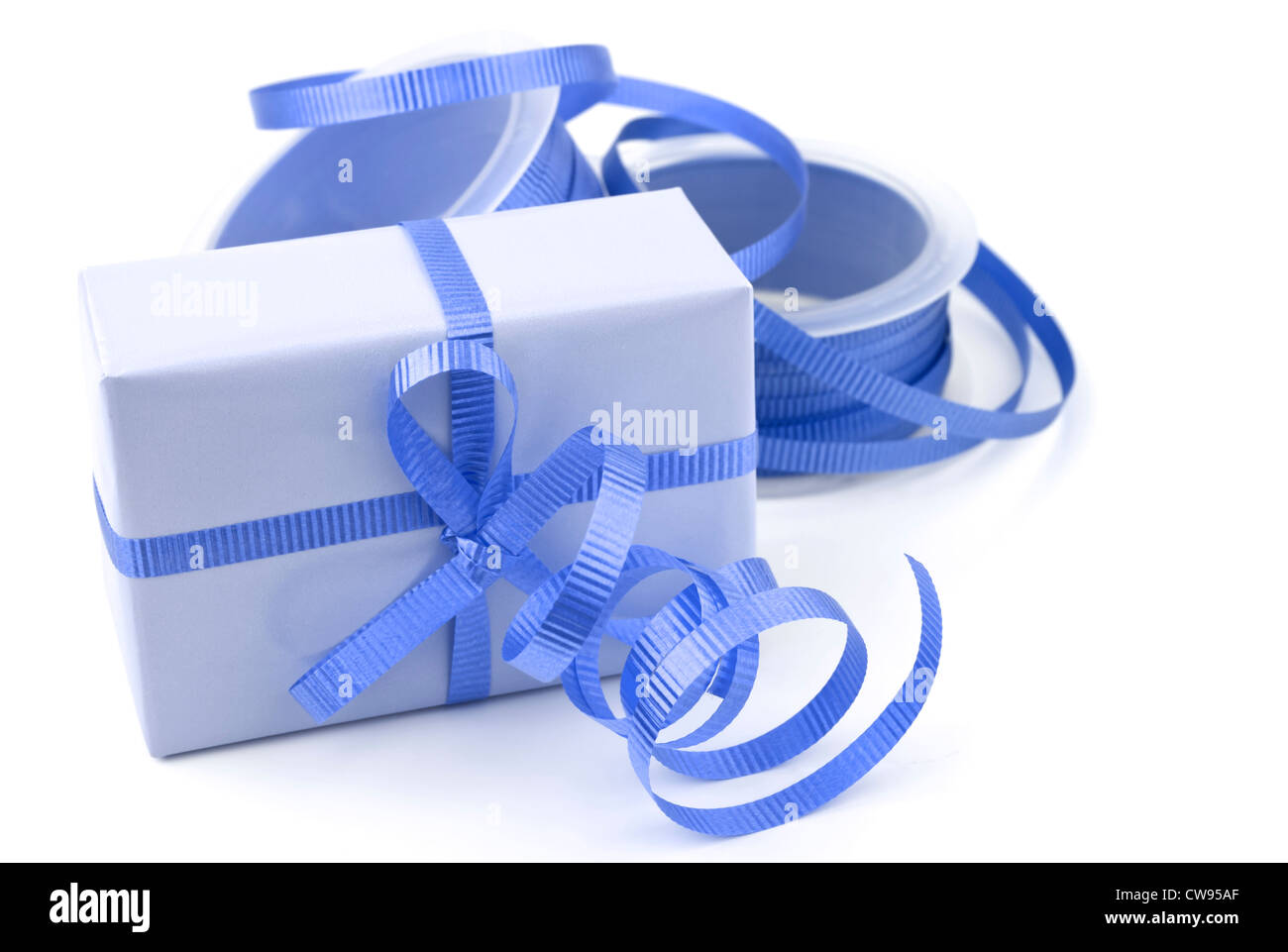Gift box wrapped in blue wrapping paper and curly ribbon isolated on ...
