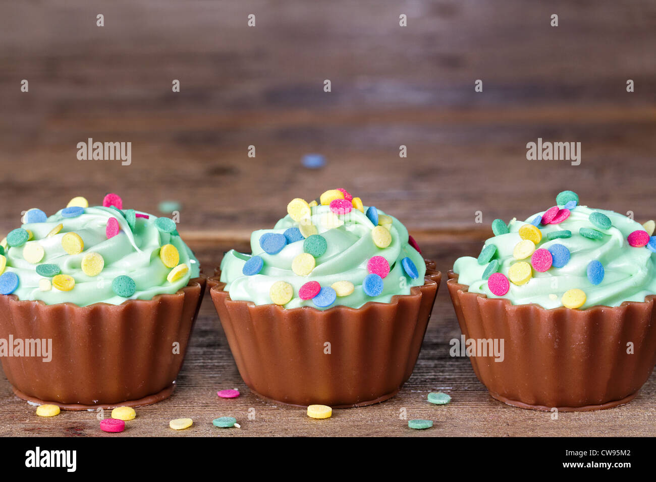 Colorful chocolate cupcakes on a rustic wooden background Stock Photo ...