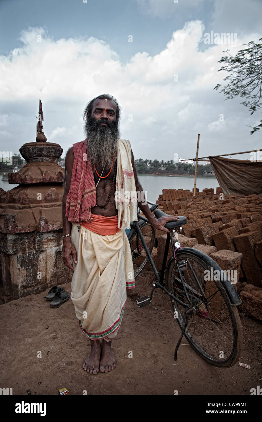 Portrait of a sadhu standing next to his bicycle. Bhubaneswar, Orissa ...