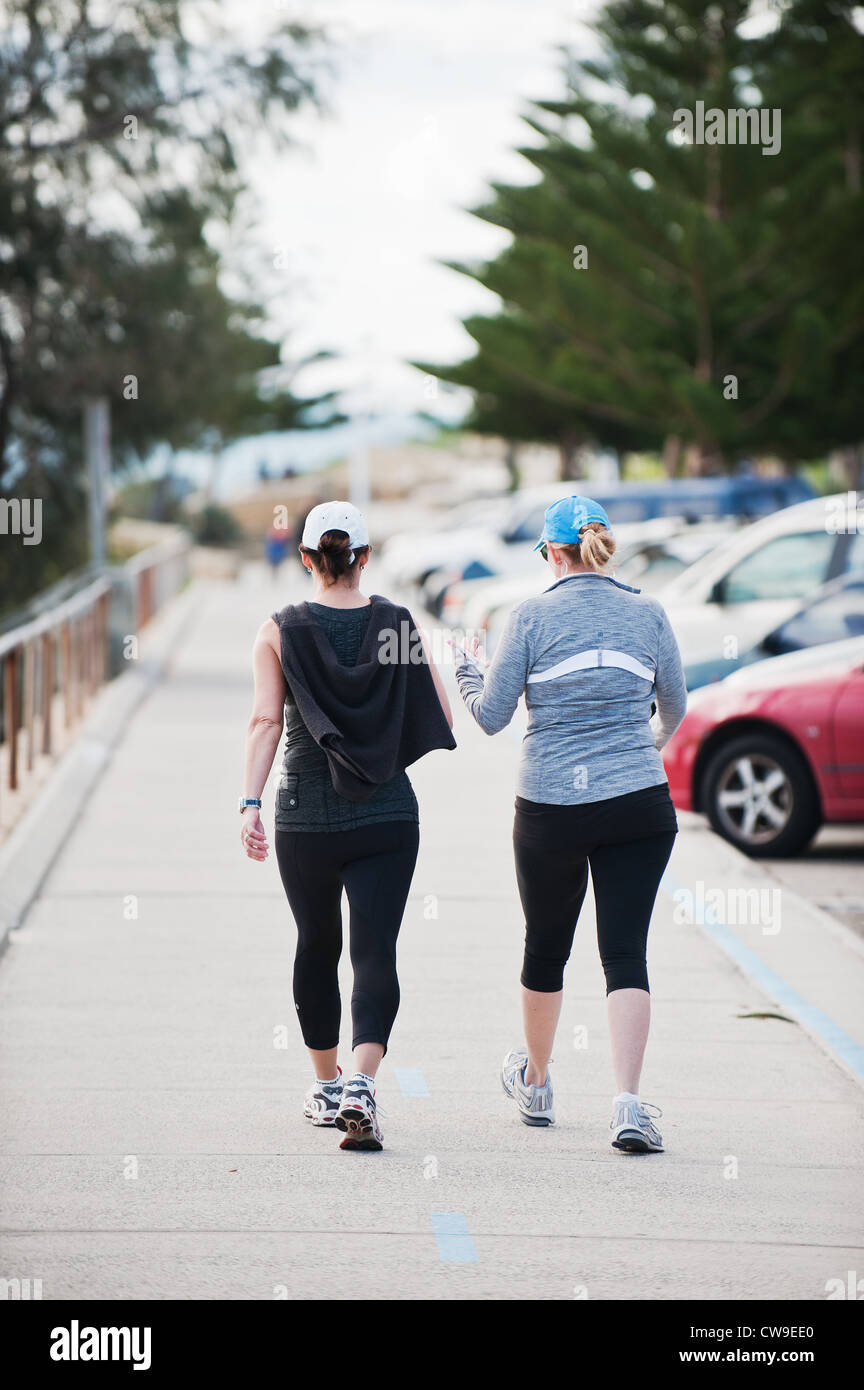Two women walking Stock Photo - Alamy