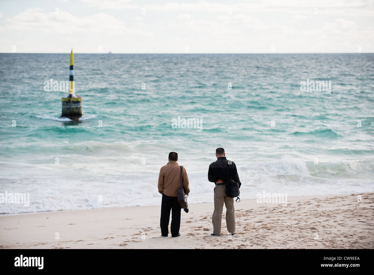 Tourists looking at the historic Pylon off Cottesloe Beach in Western ...