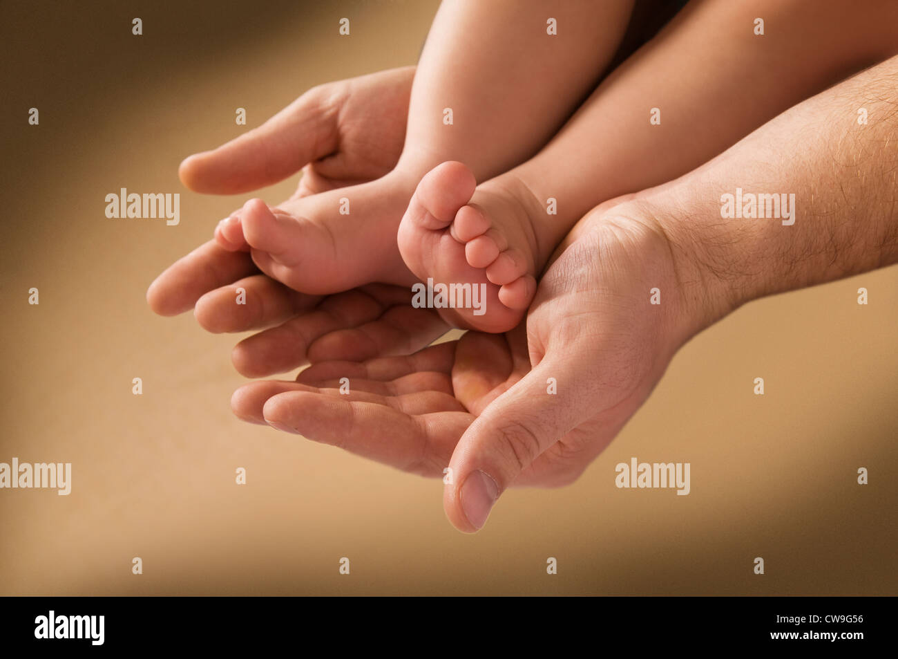 man's hand and children's foot isolated on a yellow background Stock ...