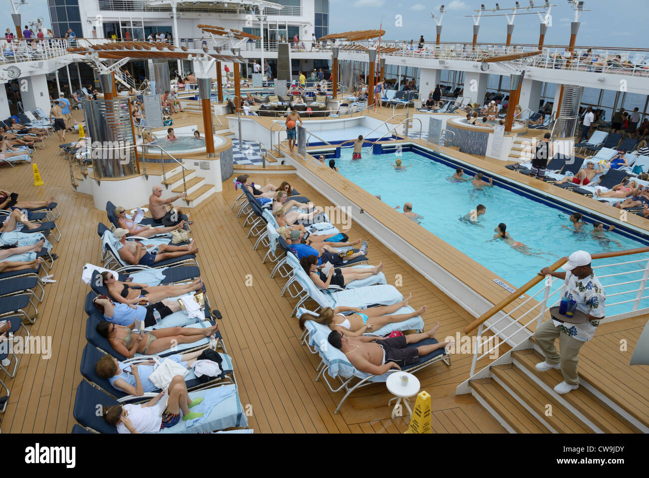 Upper deck of a cruise ship with sunbathers and swimmers Stock Photo - Alamy