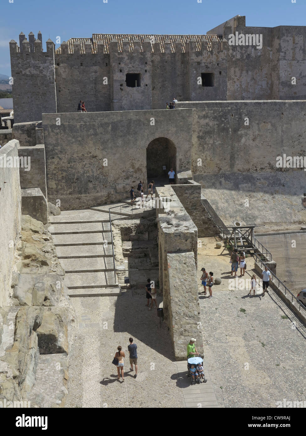 Tourists visit the castle in the historical town of Tarifa in Andalucia ...