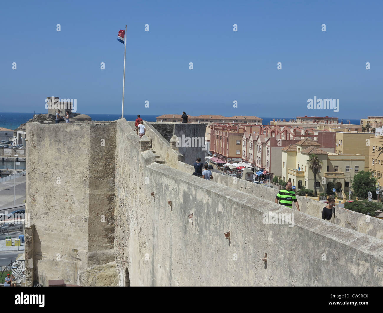 Tourists visit the castle in the historical town of Tarifa in Andalucia ...
