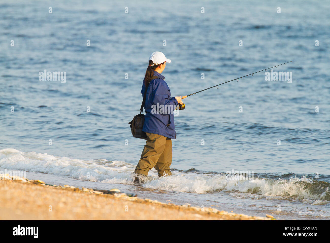 Woman wearing waders fishing in the Atlantic Ocean Stock Photo - Alamy