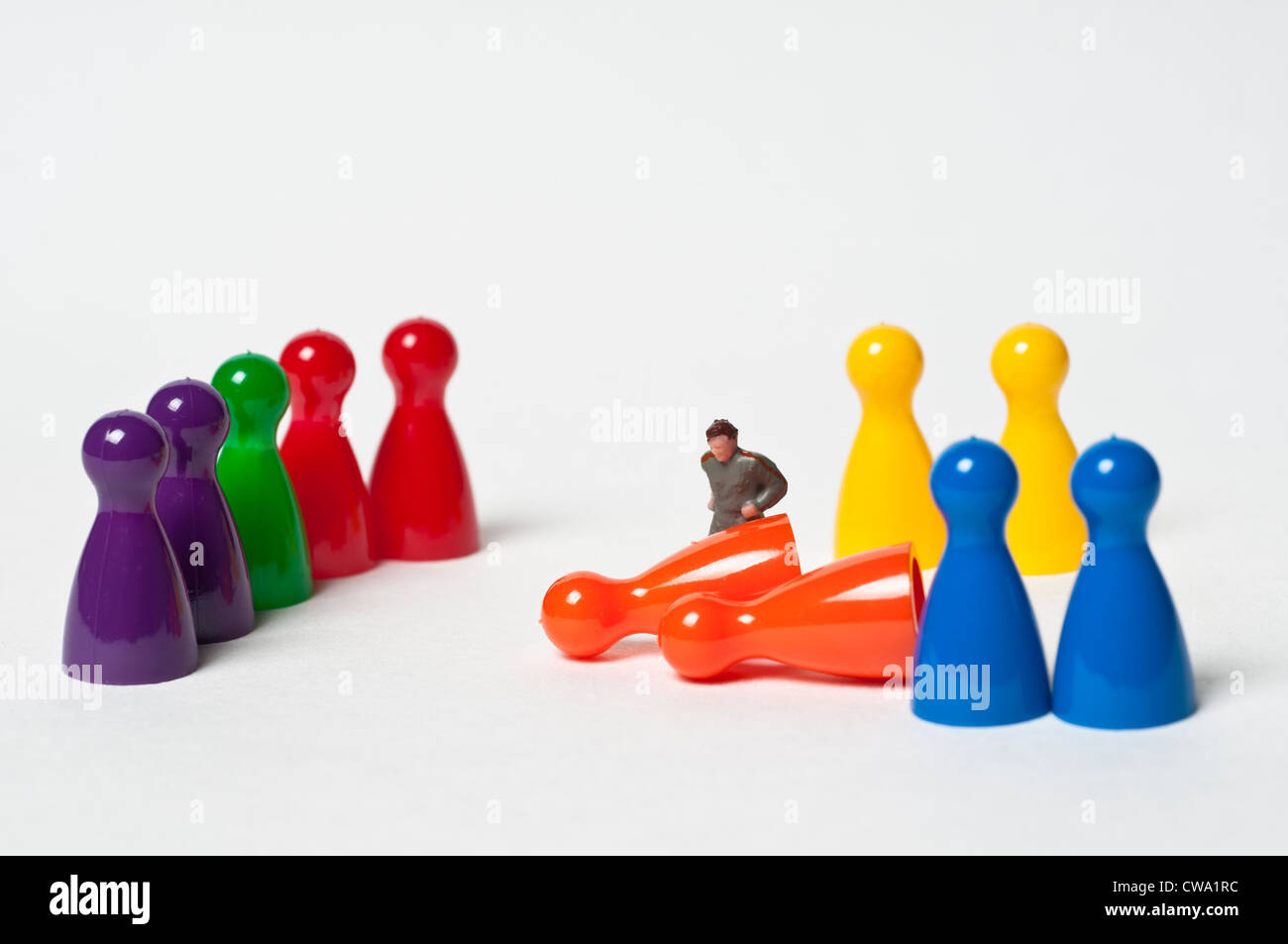 Colourful pawns and a toy figure Stock Photo - Alamy