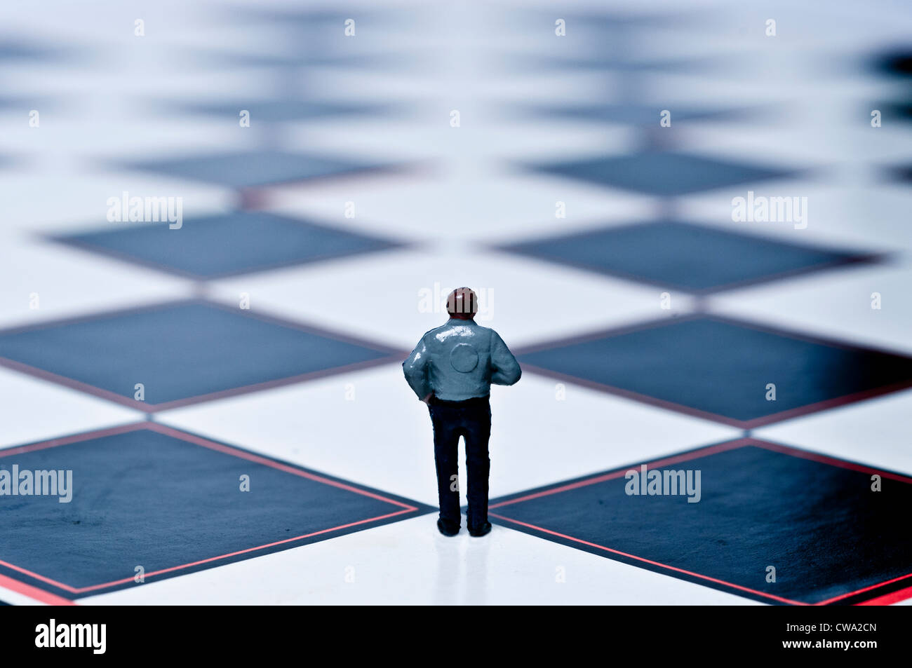 Toy man standing on a checked surface Stock Photo - Alamy