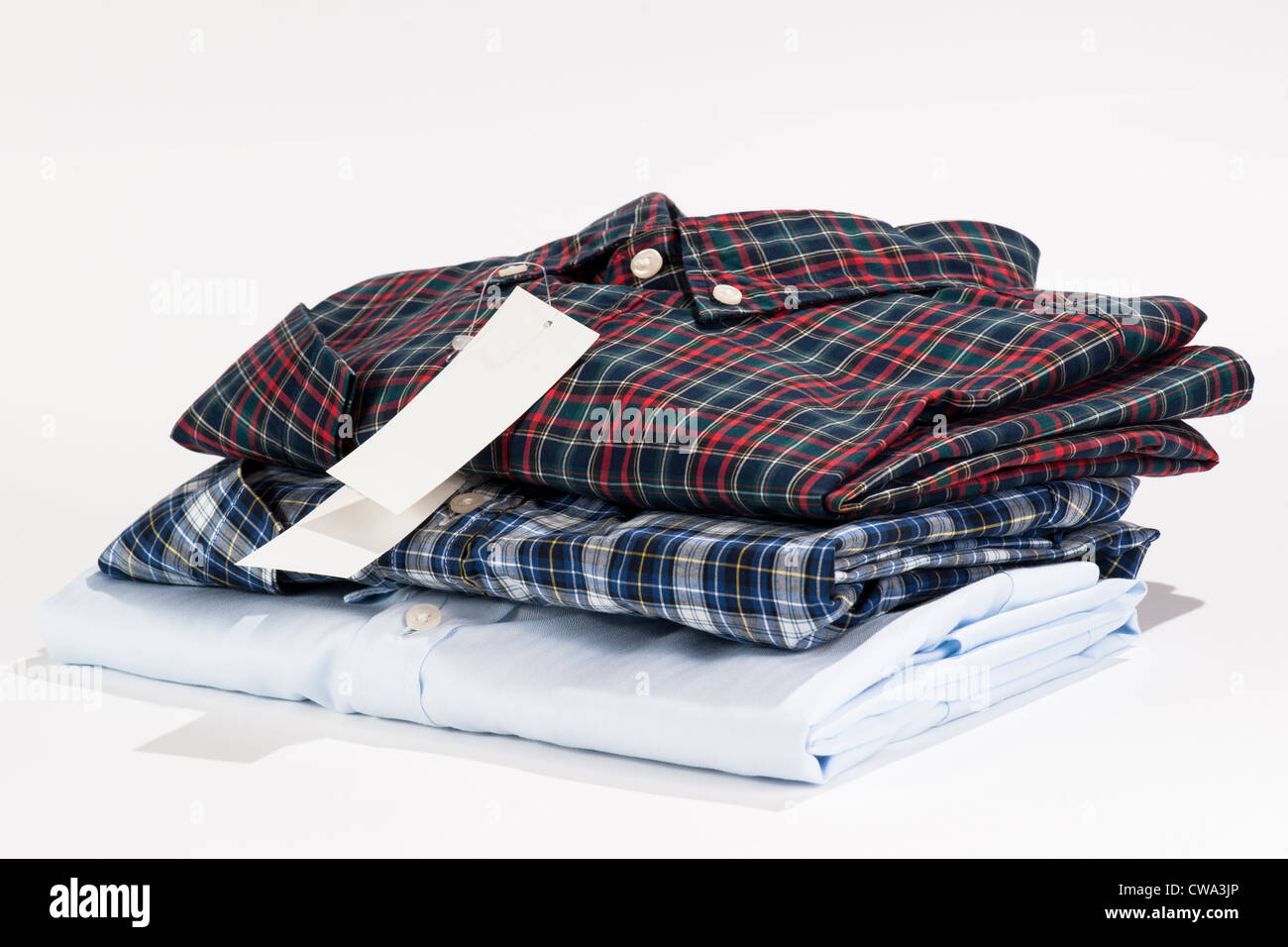 Stack of folded shirts with blank label Stock Photo - Alamy
