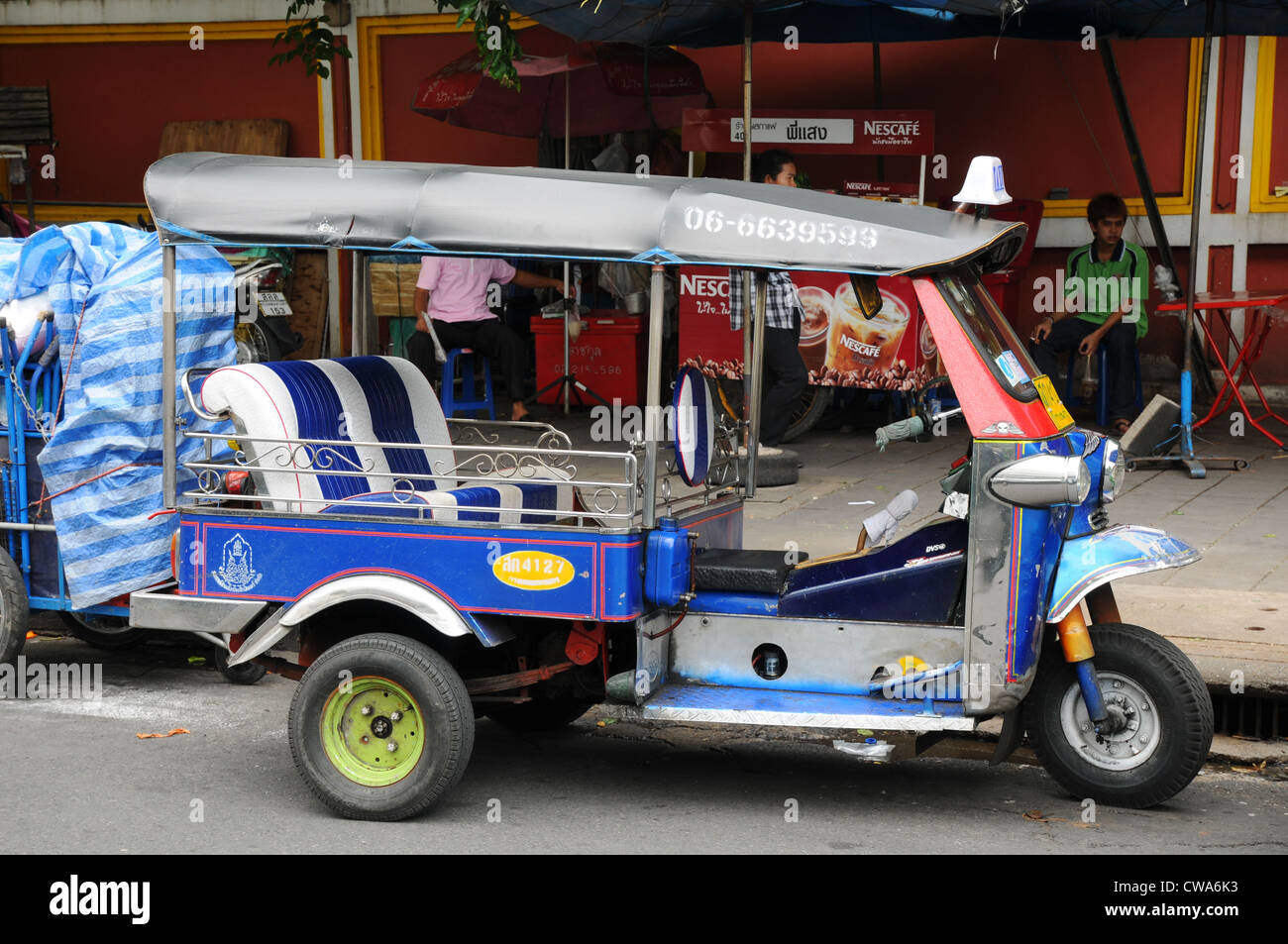 Blue tuk-tuk parked off Sukhumvit Road awaiting passengers, Bangkok ...