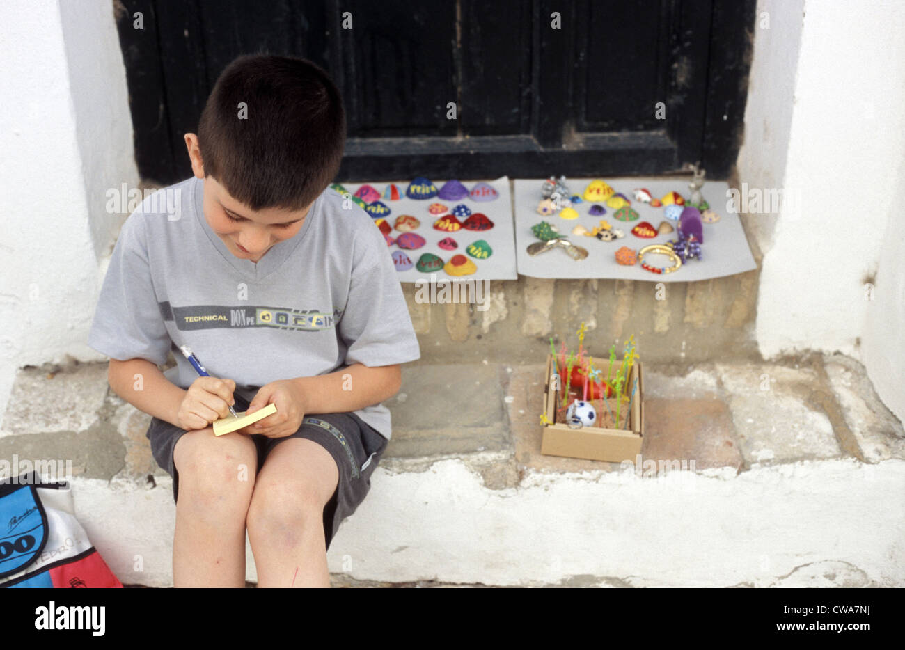 Little boy to his sales listed on tourists Stock Photo - Alamy