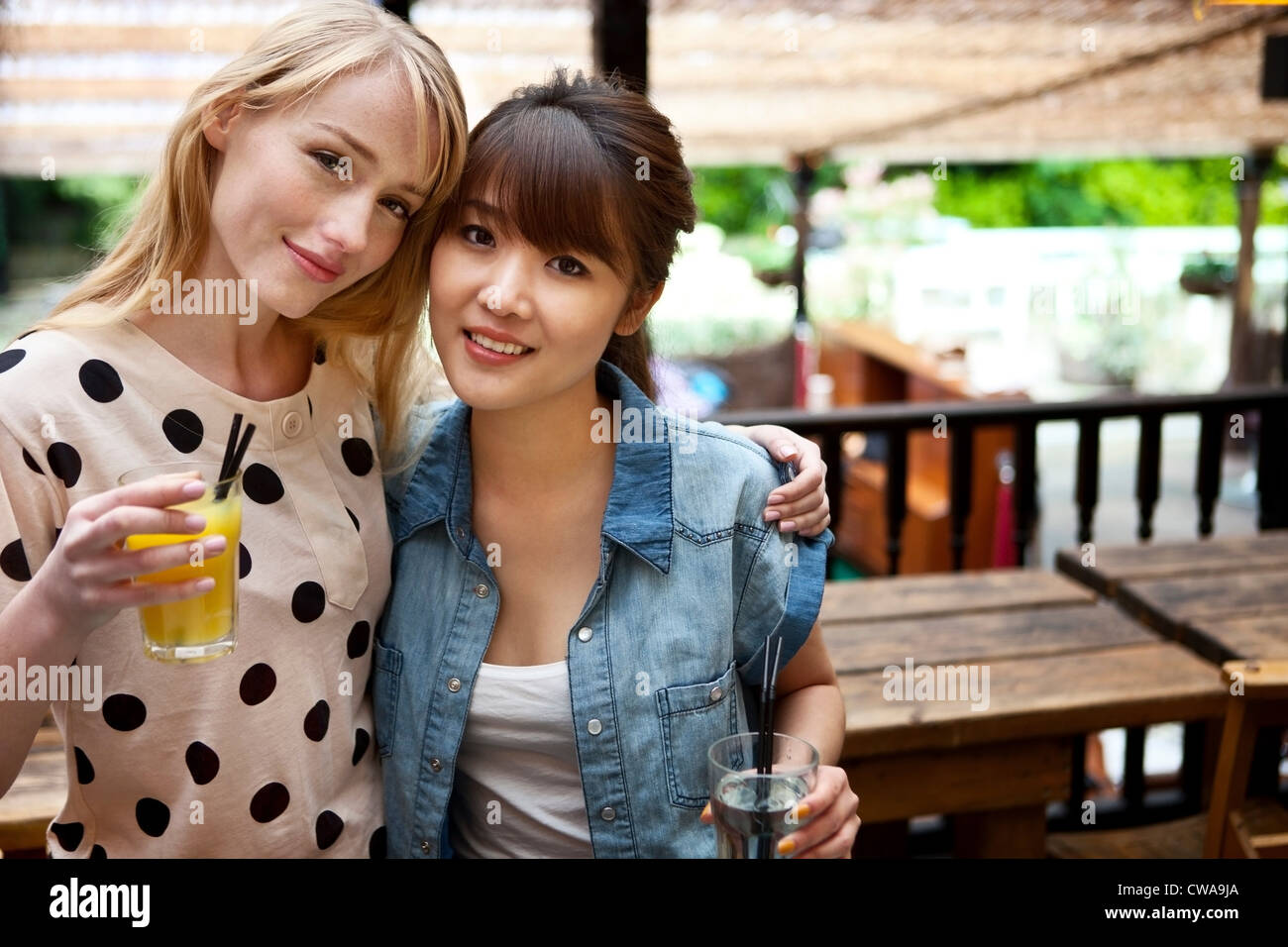 Female friends posing with soft drinks Stock Photo - Alamy