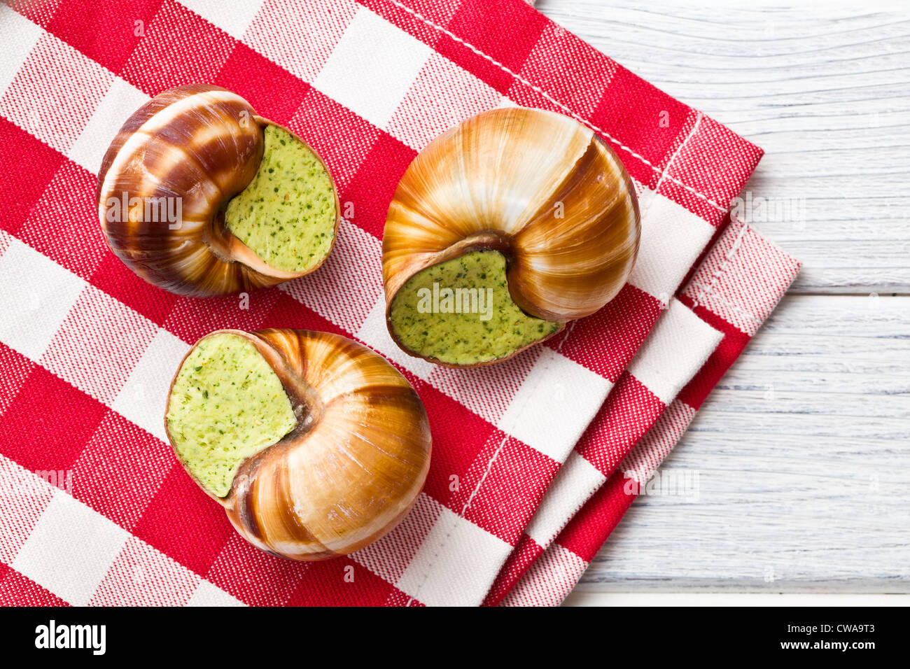 snails with butter and parsley on kitchen table Stock Photo - Alamy