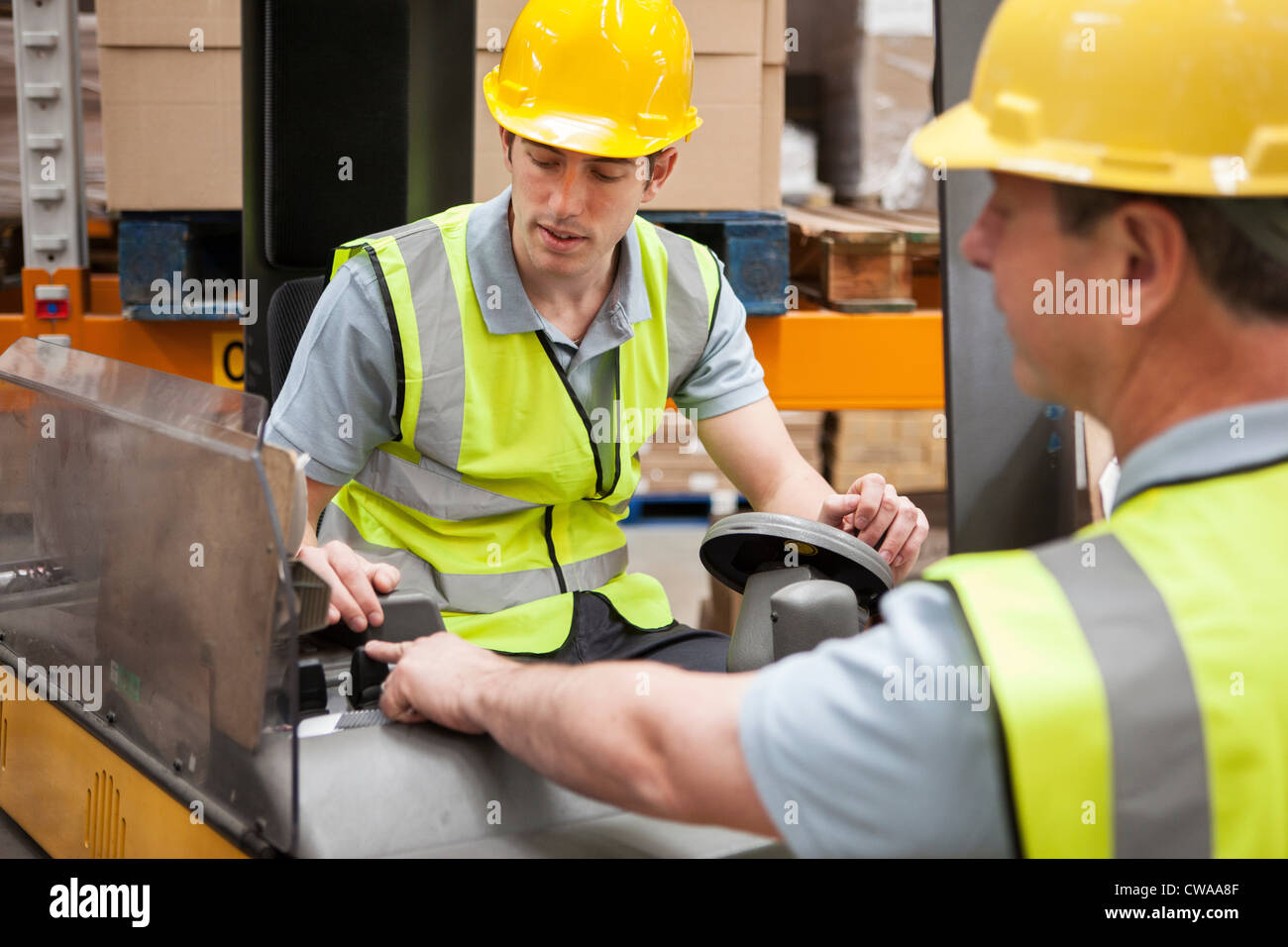 Men with machinery in warehouse Stock Photo - Alamy