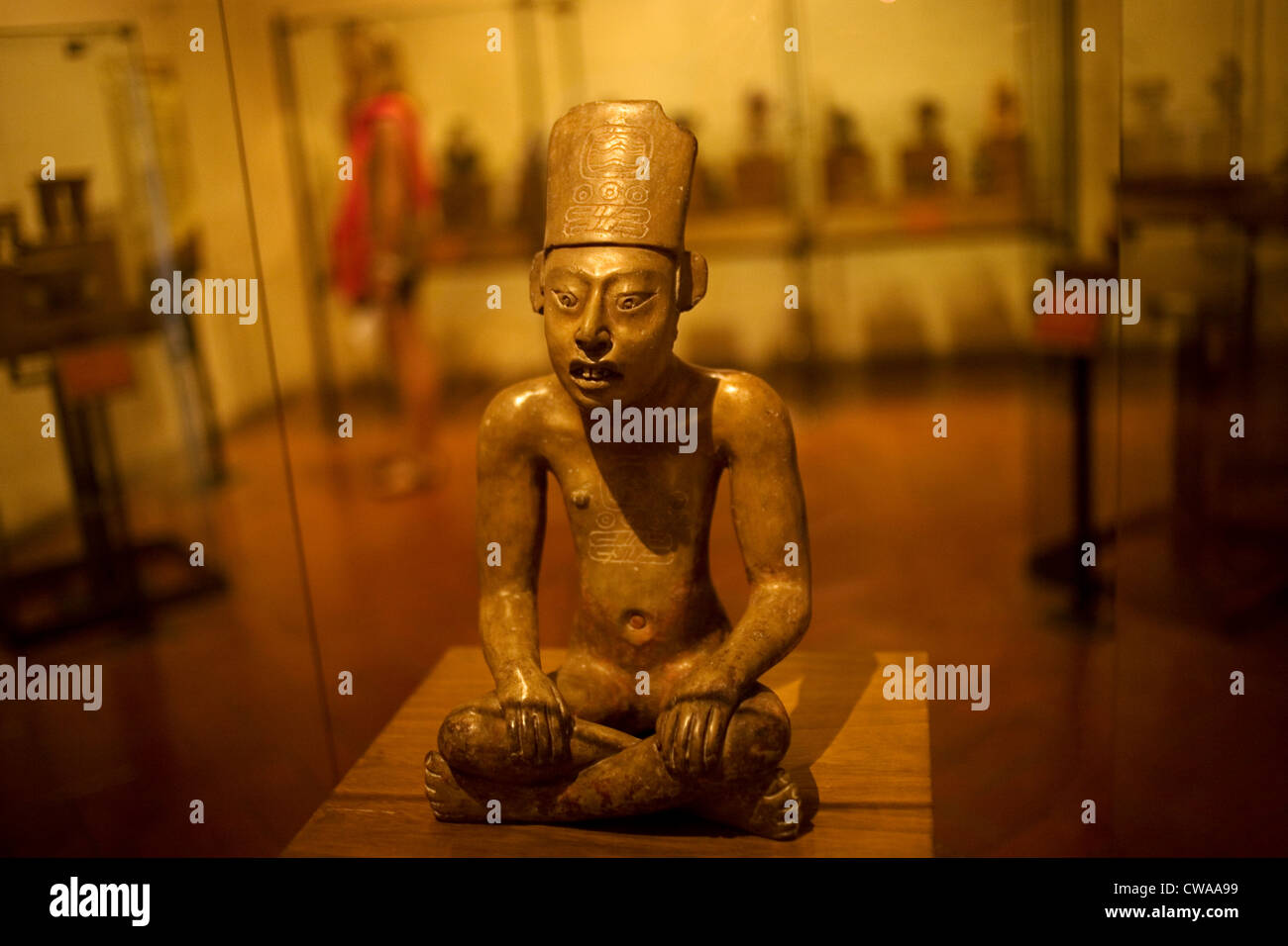 A sculpture of a man sitting on the floor cross-legged in the Museum of ...