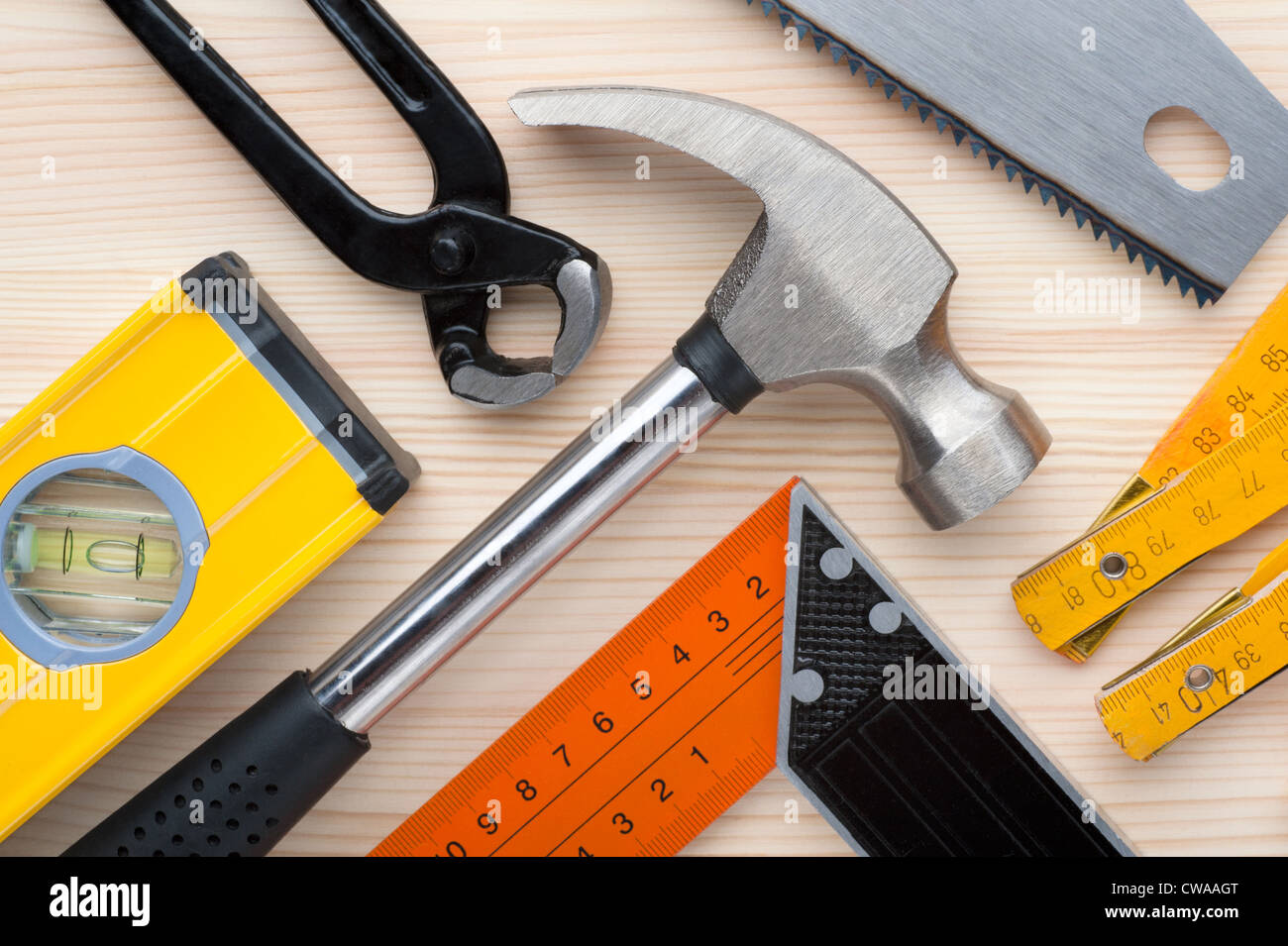 Assorted construction and measurement tools arranged on a wooden ...