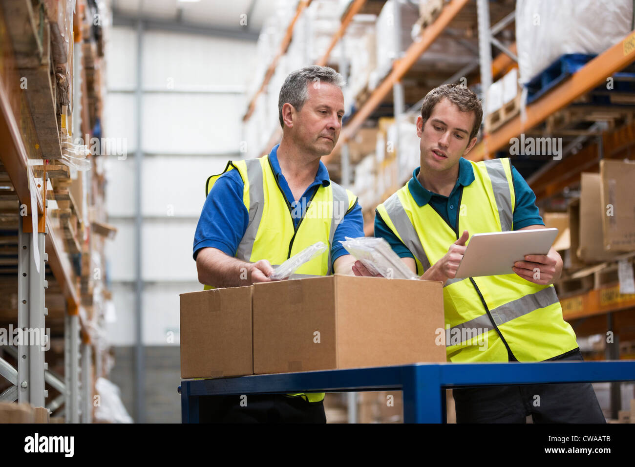 Two men checking stock in warehouse Stock Photo - Alamy