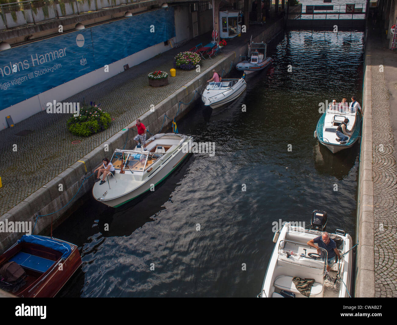 Small pleasure boats pass through the lock at Slussen that connects ...