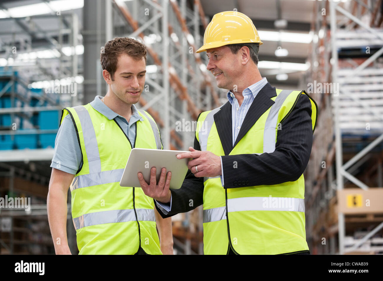 Men in warehouse using digital tablet Stock Photo - Alamy