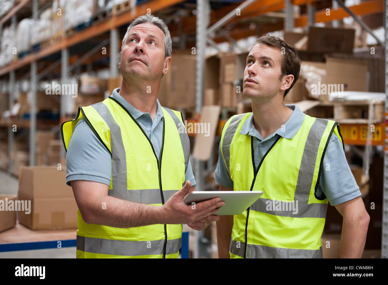Men in warehouse using digital tablet Stock Photo - Alamy