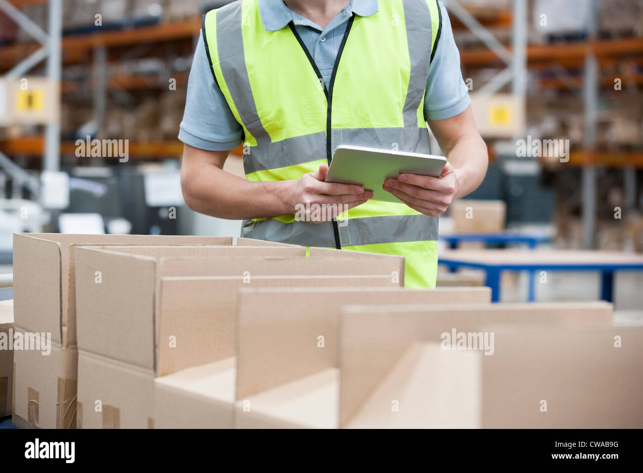 Man with digital tablet and cardboard boxes Stock Photo - Alamy