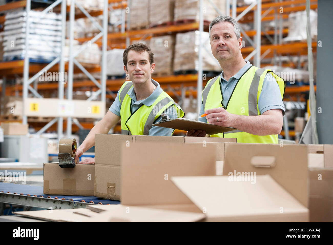 Two men checking stock in warehouse Stock Photo - Alamy
