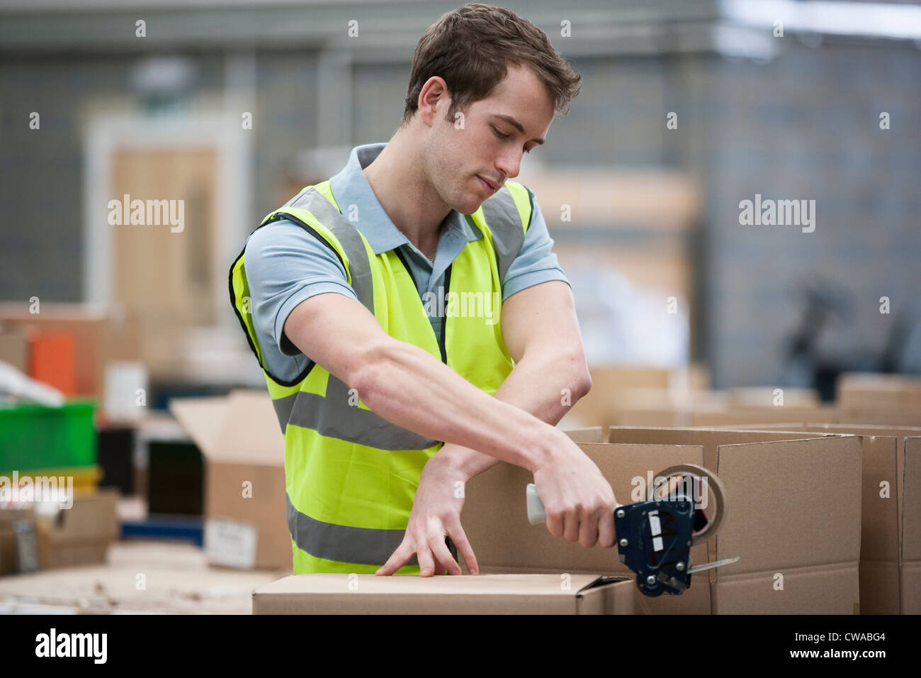 Man packing cardboard box in warehouse Stock Photo - Alamy