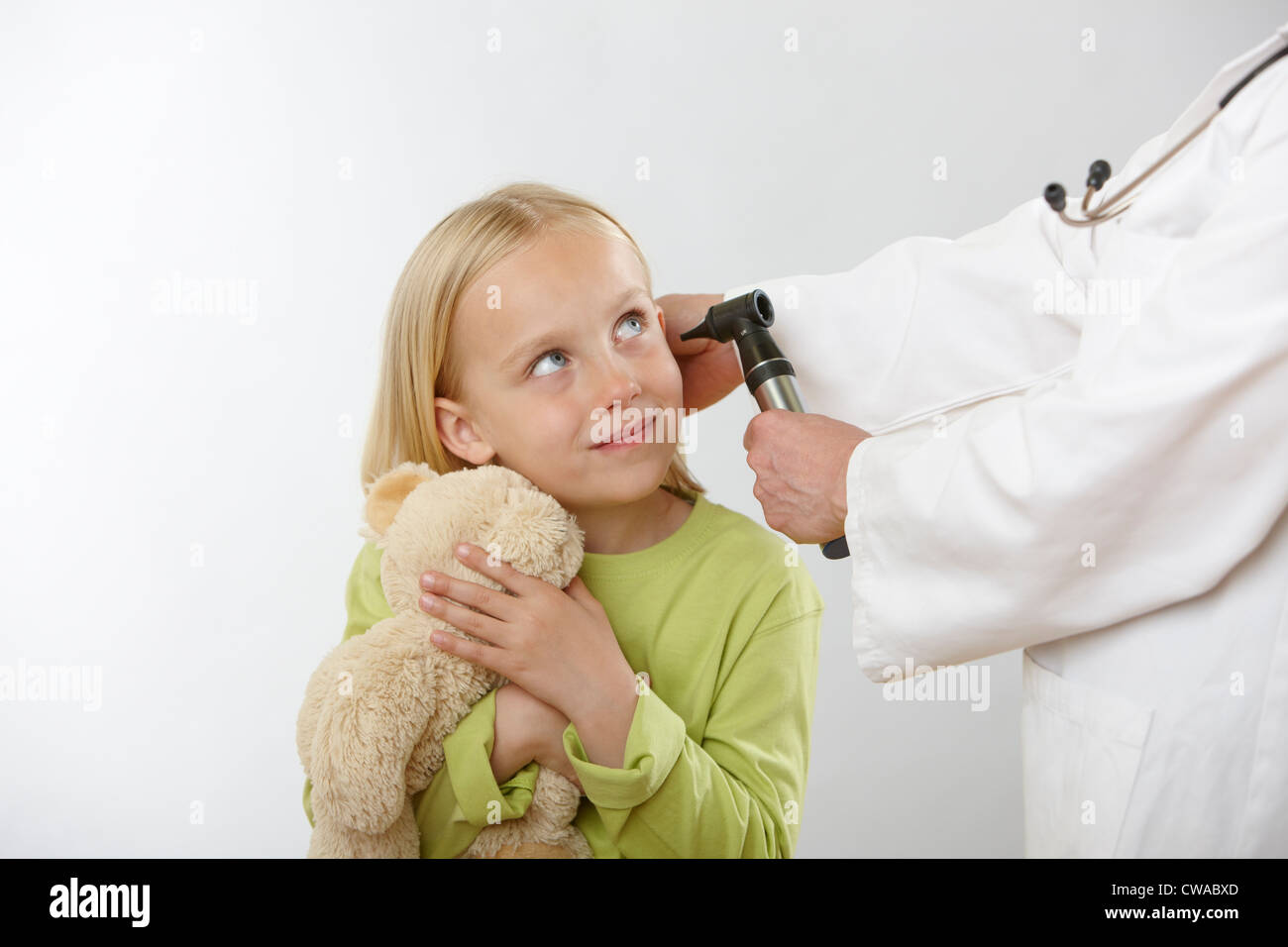 Doctor examining girl's ear Stock Photo - Alamy