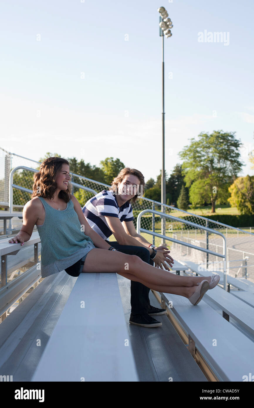 Teenage couple sitting on bleachers Stock Photo - Alamy