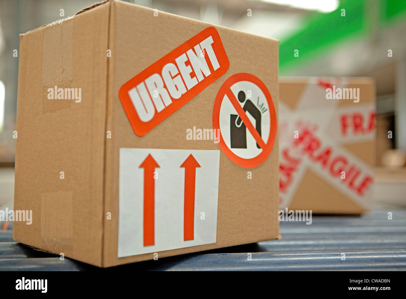 Cardboard box with warning stickers on conveyor belt Stock Photo - Alamy