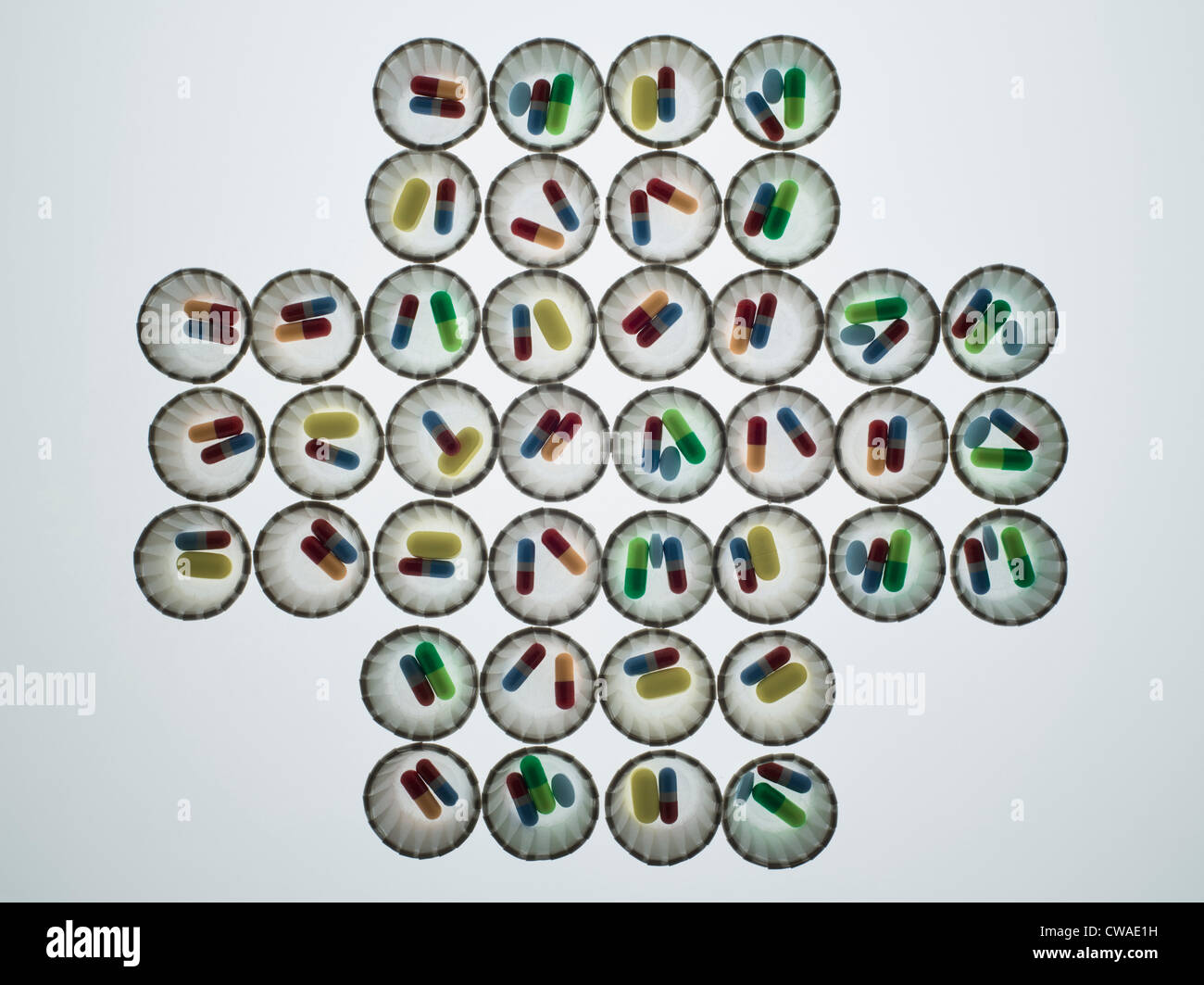 Dispenser cups of pills forming a cross shape Stock Photo - Alamy