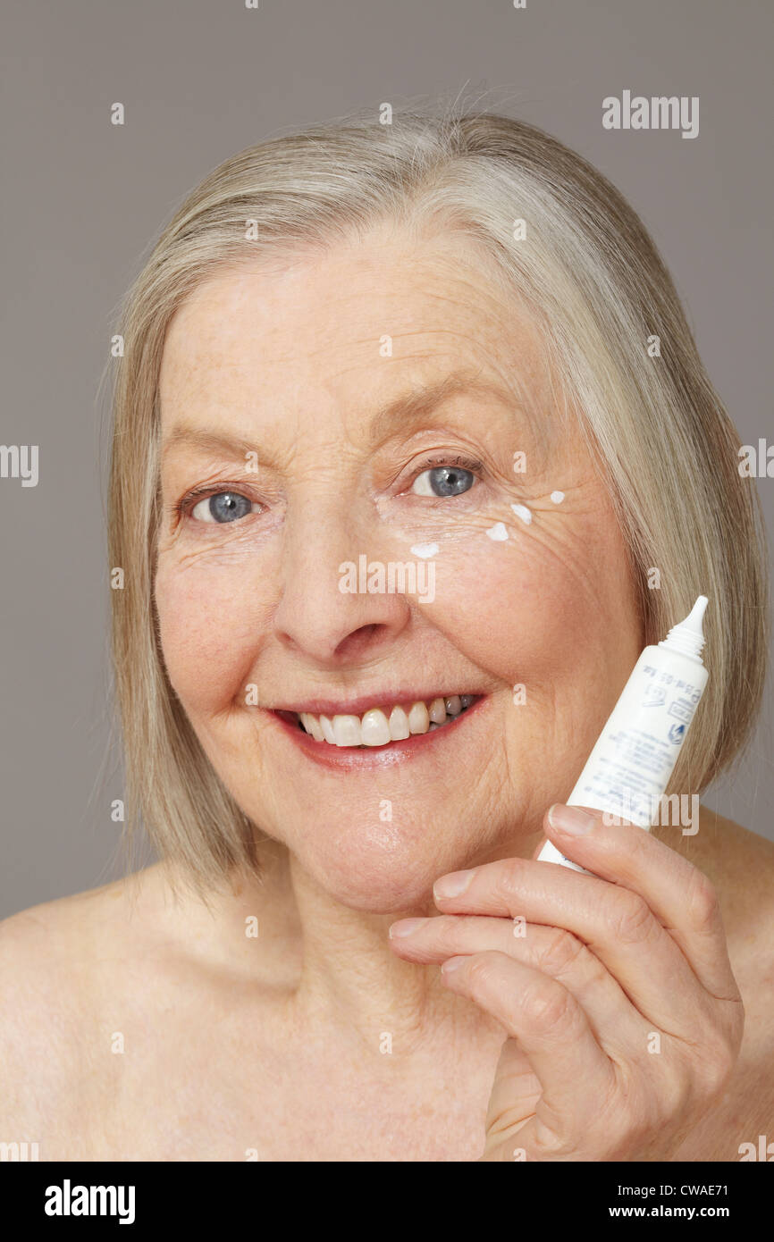 Senior woman applying eye cream Stock Photo - Alamy