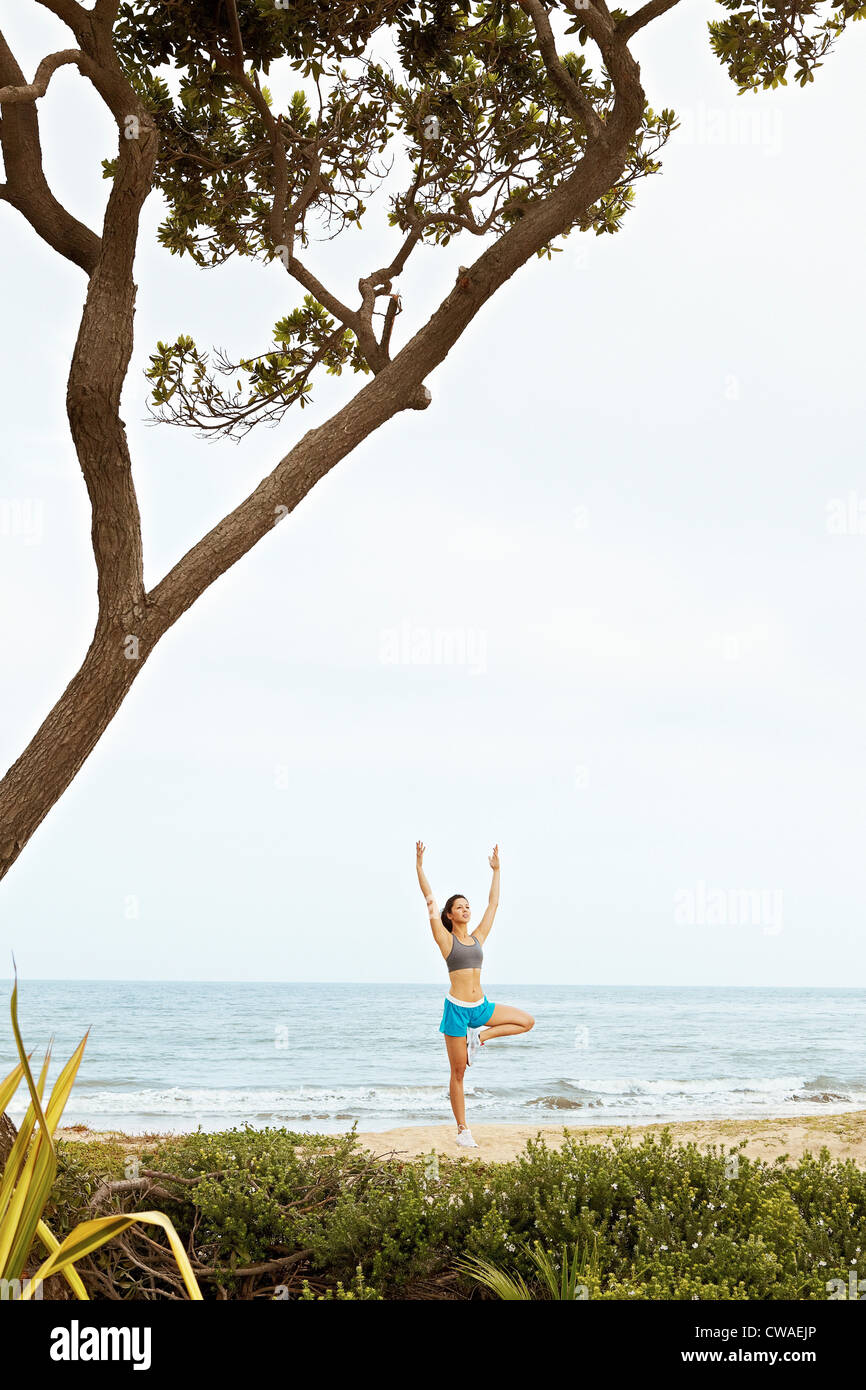 Young woman stretching on beach Stock Photo - Alamy