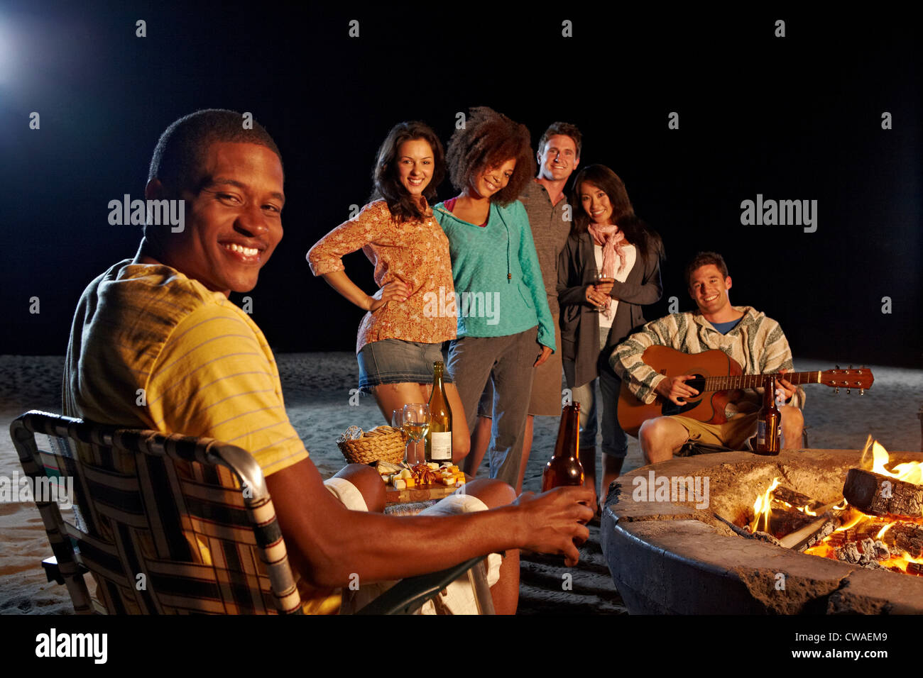 Friends having beach party at night Stock Photo - Alamy