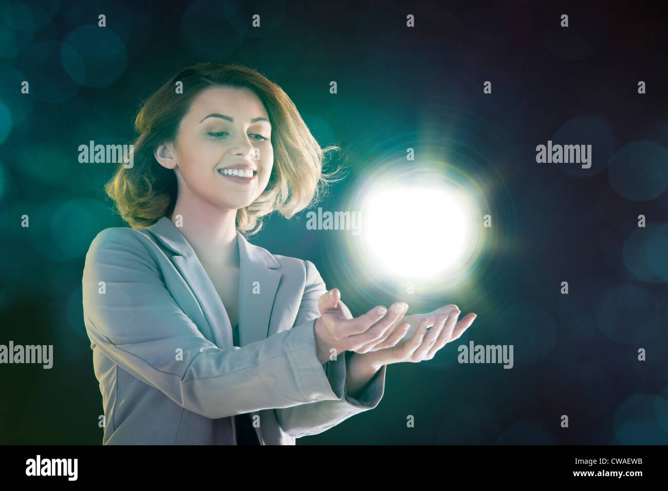 Young woman holding ball of light Stock Photo - Alamy