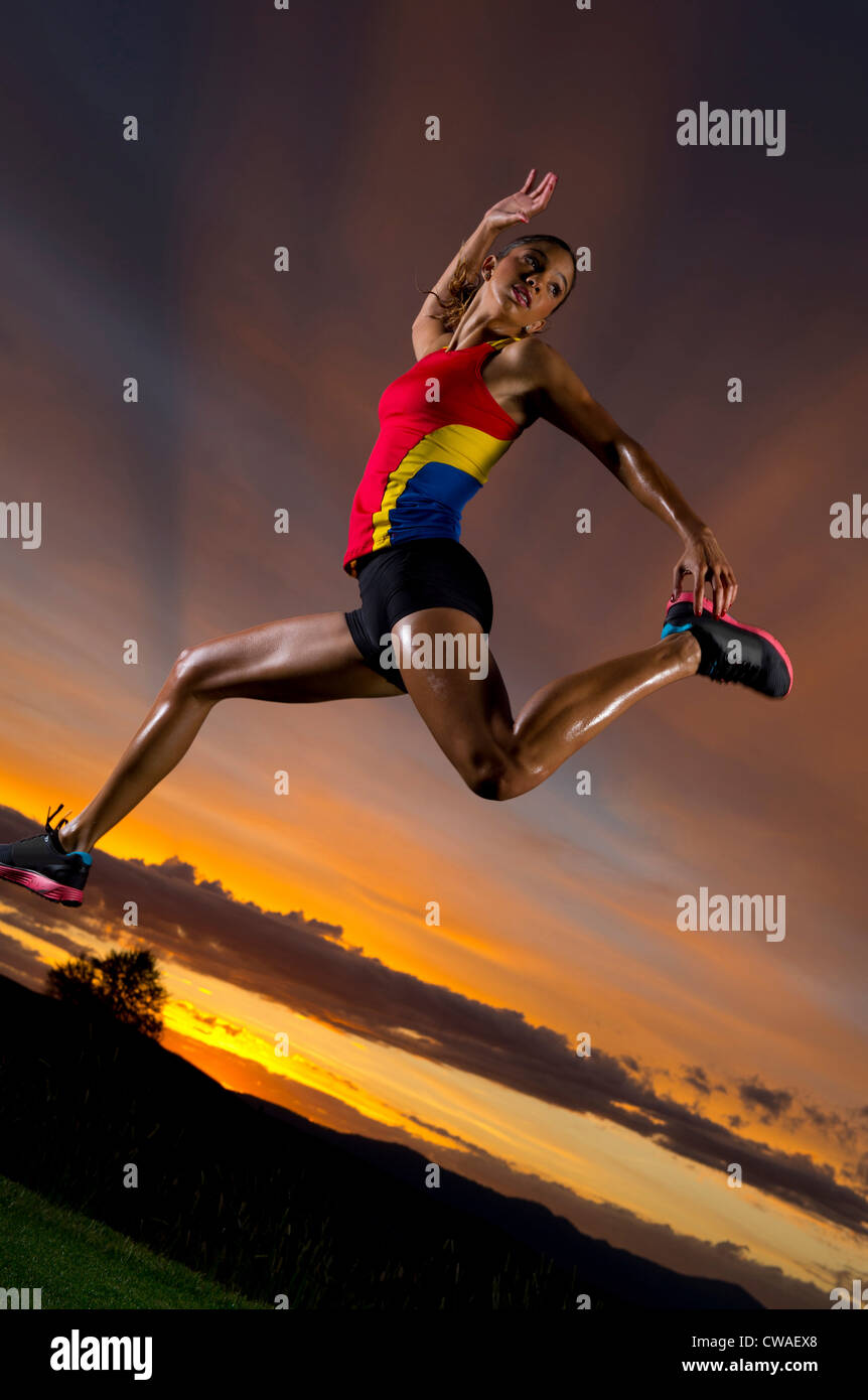 Athlete jumping against sunset Stock Photo - Alamy