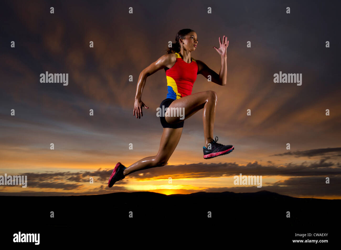 Athlete in mid air against sunset Stock Photo - Alamy