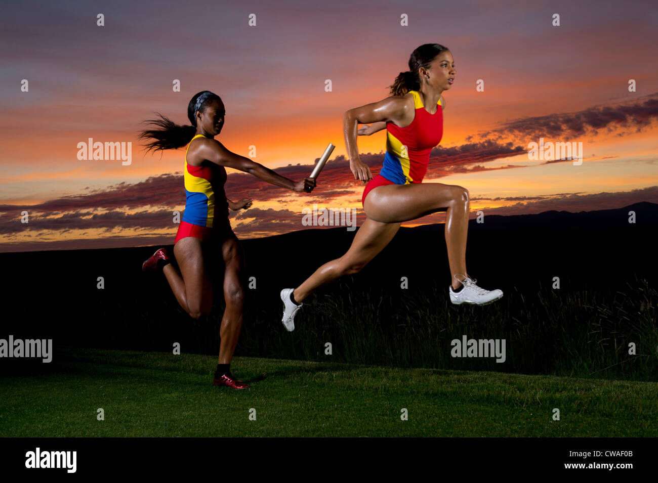 Female relay racers passing baton Stock Photo - Alamy