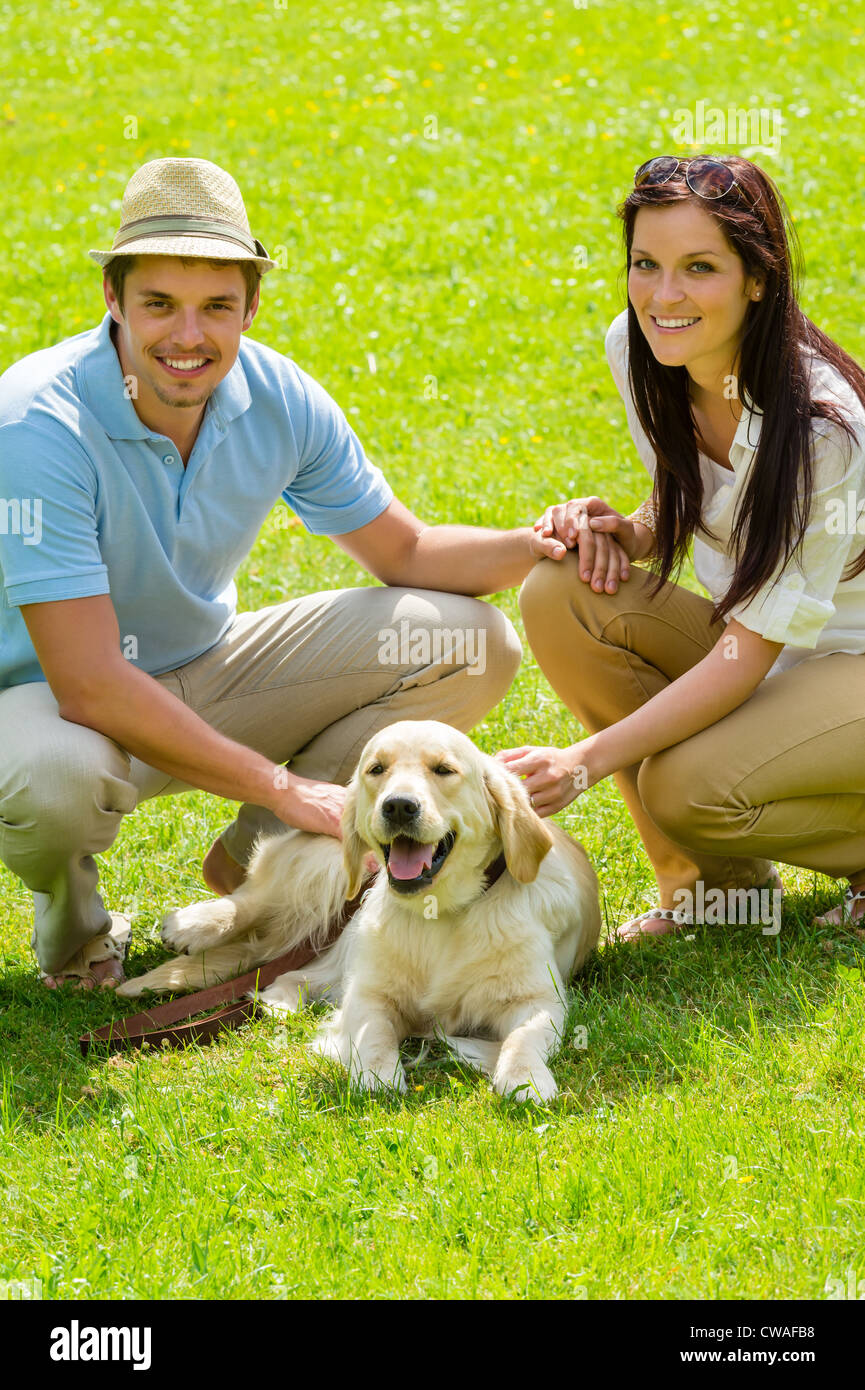 Young happy couple with Labrador dog smiling in park Stock Photo - Alamy